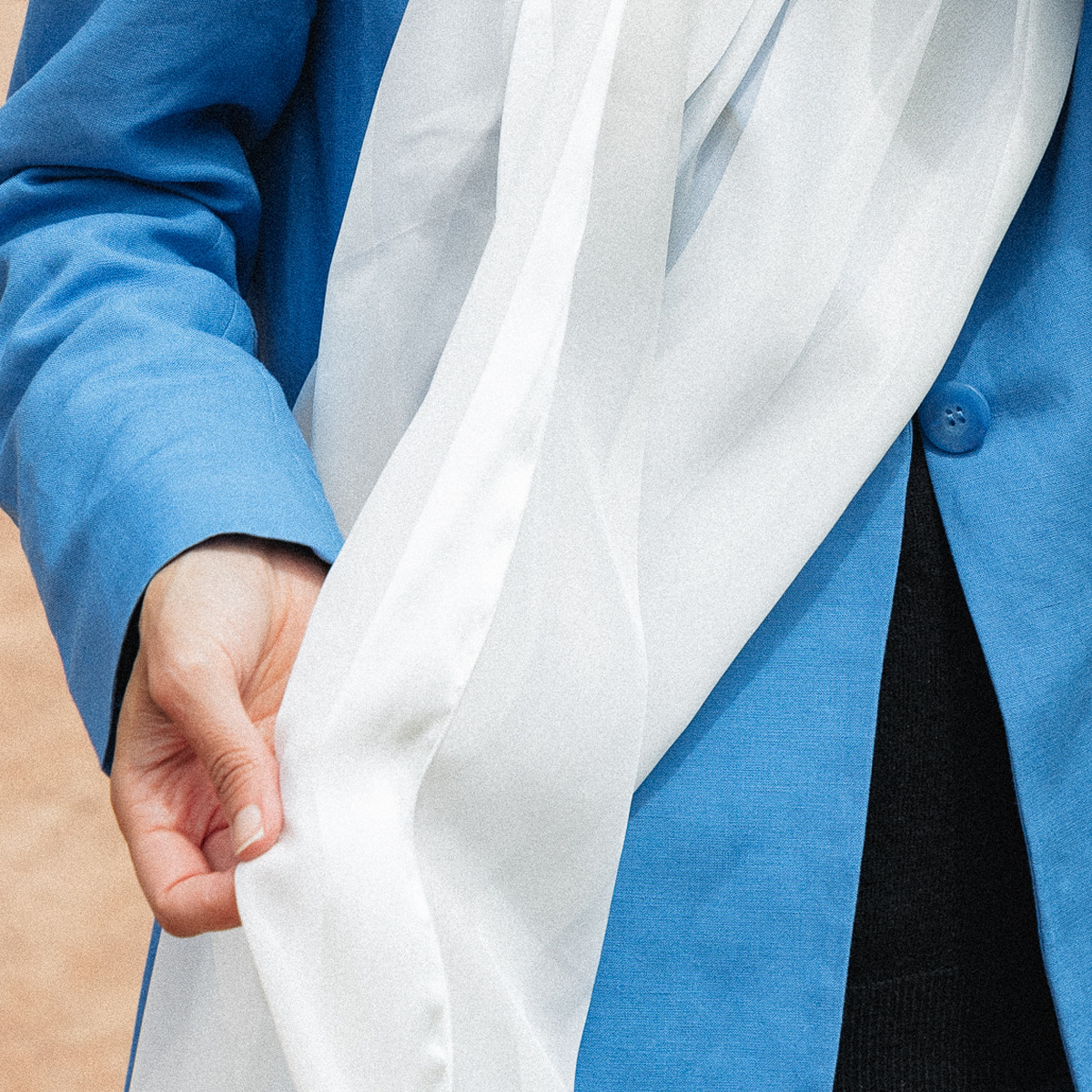 A large white silk ceremonial stole featuring chiffon and satin bands.